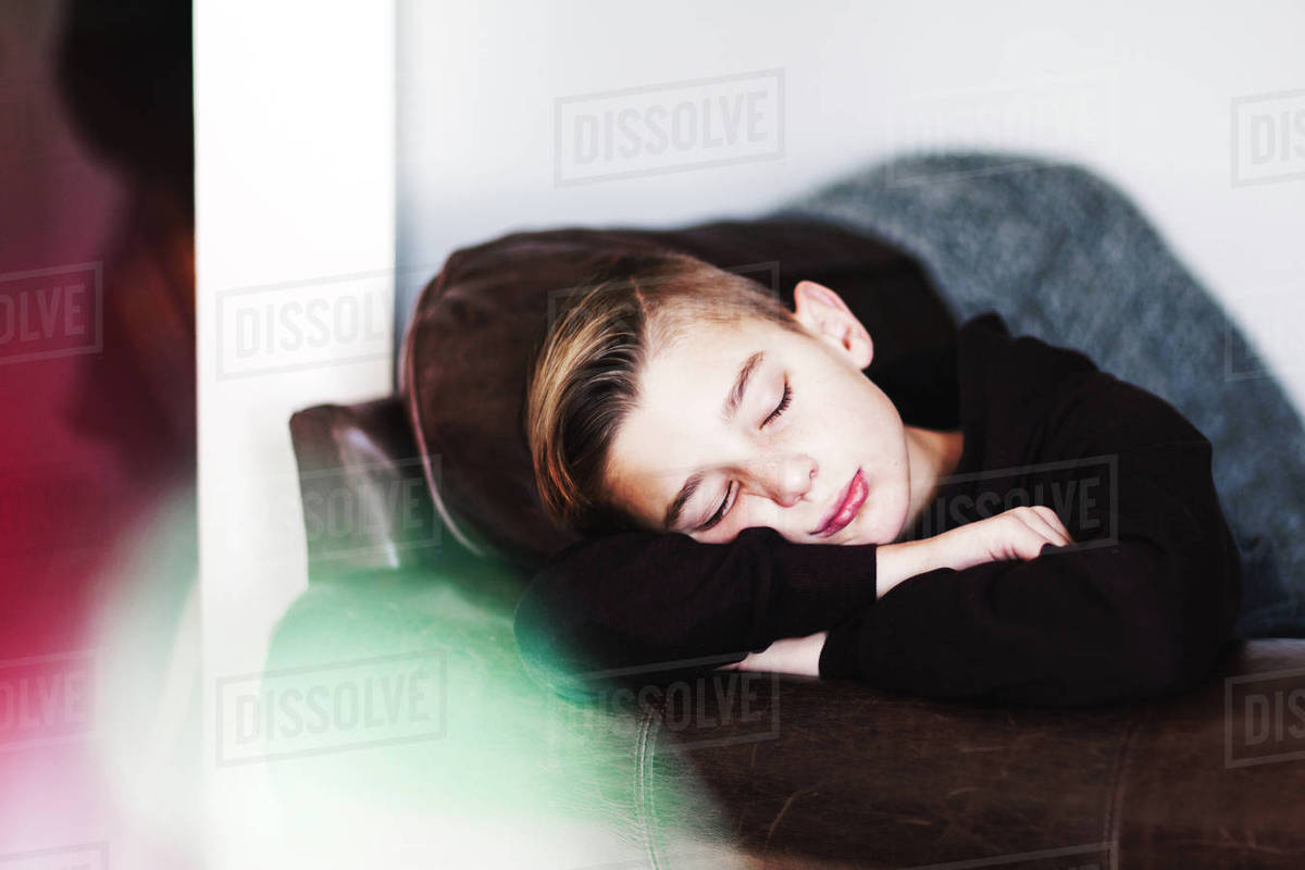 Boy sleeping on leather sofa - Royalty-free Stock Photo | Dissolve