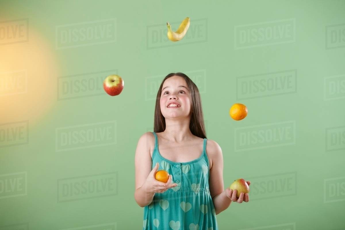 Girl juggling fruit - Royalty-free Stock Photo | Dissolve