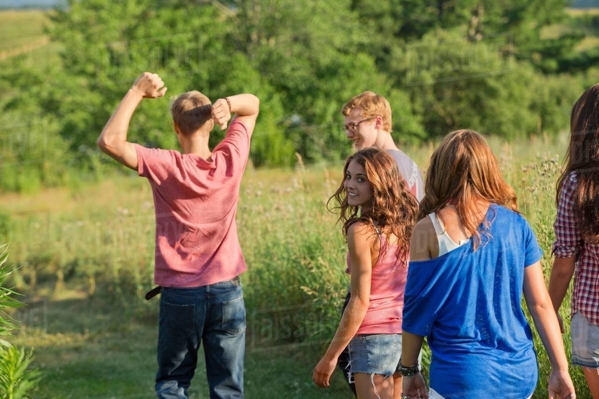 Five friends walking through field - Royalty-free Stock Photo | Dissolve