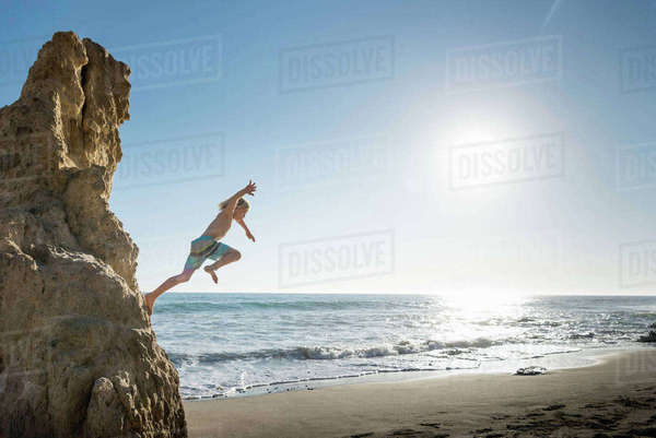 Boy jumping off rock, El Matador Beach, Malibu, USA - Royalty-free ...