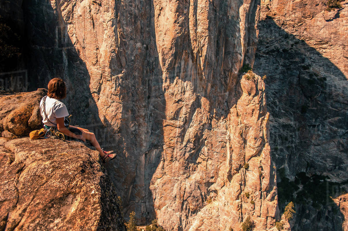 Rock climber on Higher Cathedral Spire looking away at view, Yosemite ...