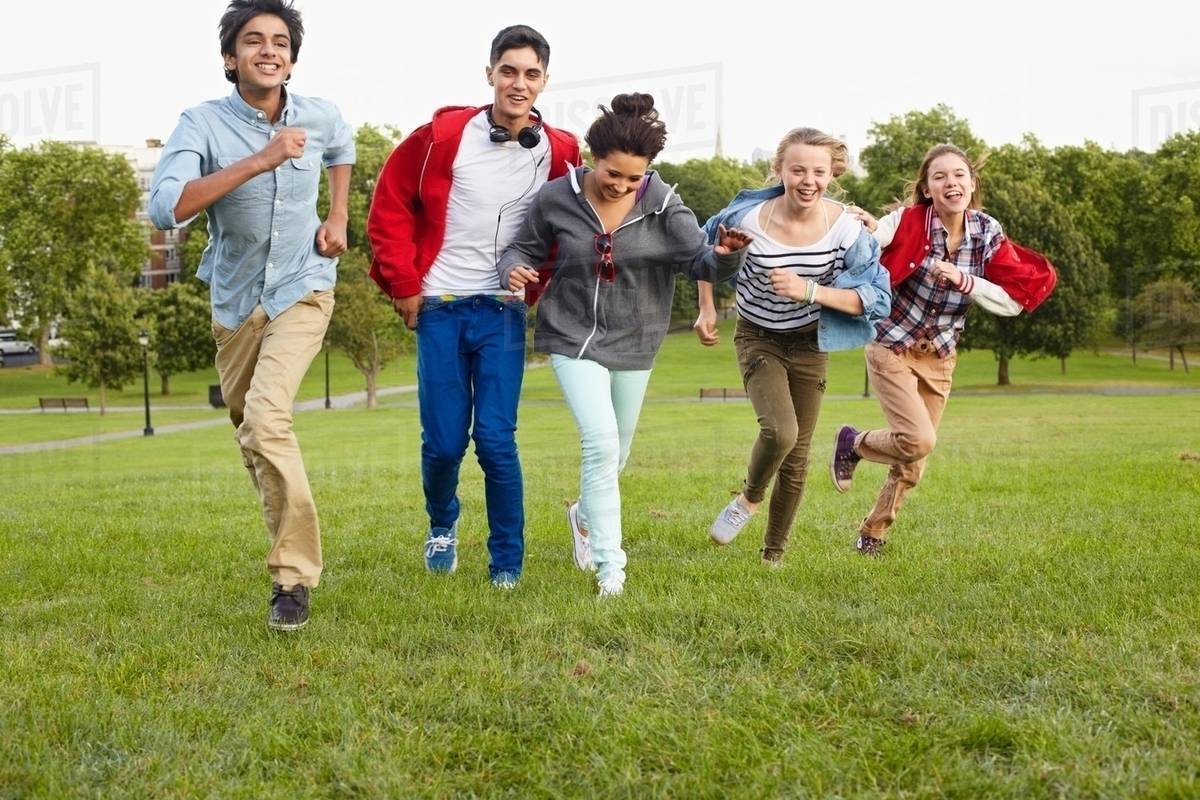 Teenagers running in a park - Royalty-free Stock Photo | Dissolve