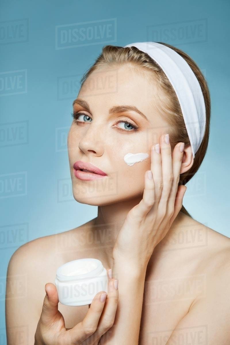 Woman applying moisturiser - Royalty-free Stock Photo | Dissolve