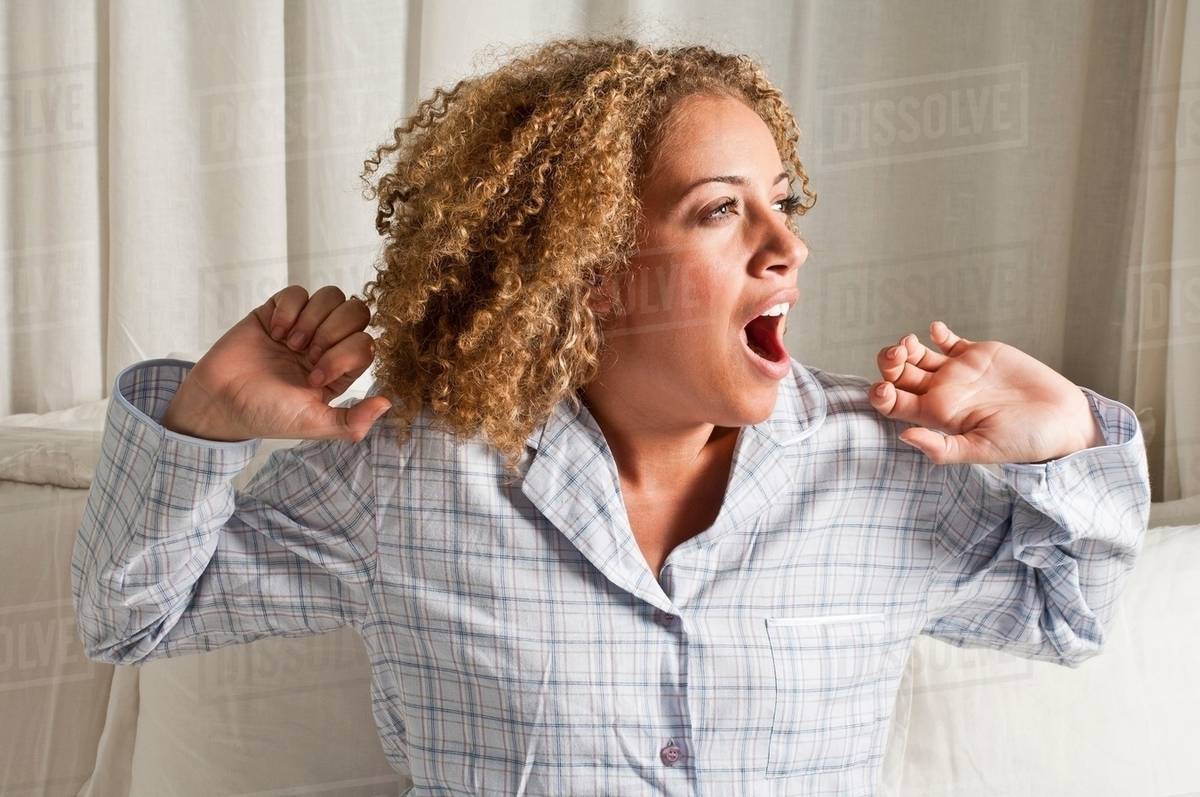 Woman stretching and yawning - Stock Photo - Dissolve