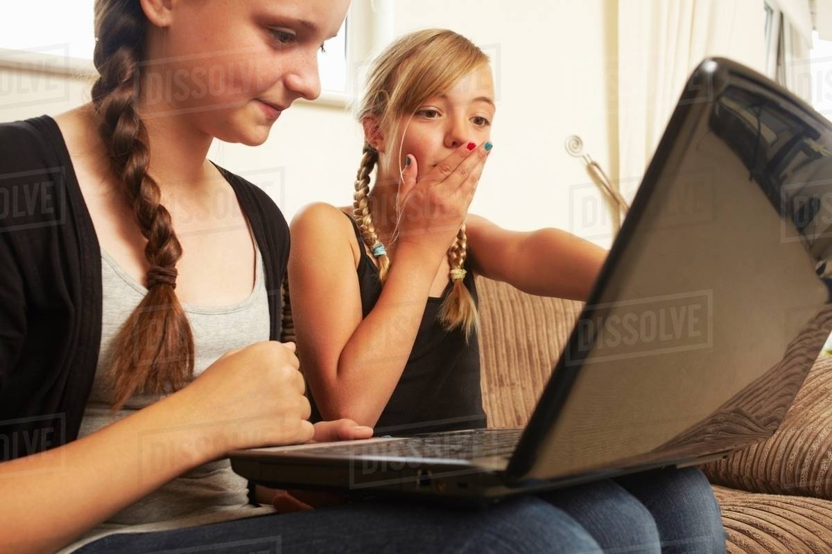 Two girls using laptop - Royalty-free Stock Photo | Dissolve