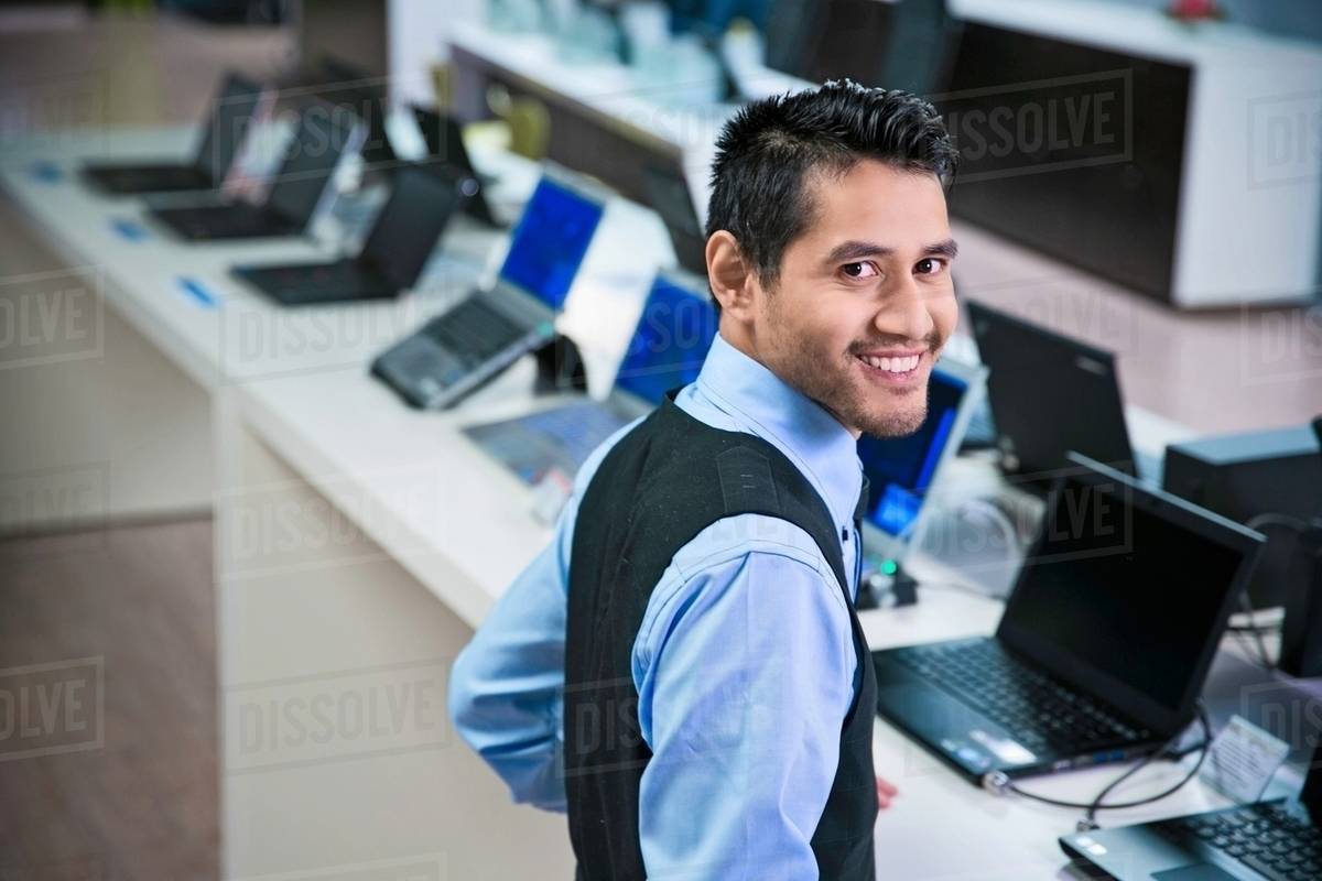 Salesman smiling in store - Royalty-free Stock Photo | Dissolve