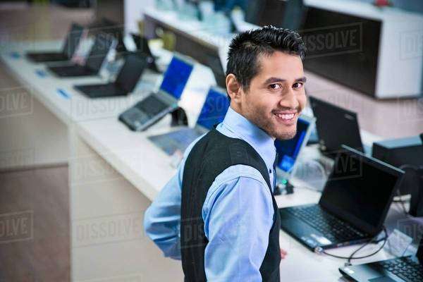Salesman smiling in store - Royalty-free Stock Photo | Dissolve