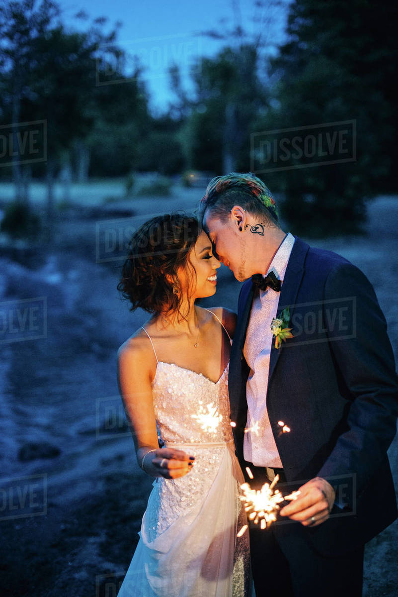 Romantic bride and groom with sparklers on lakeside at dusk - Royalty ...