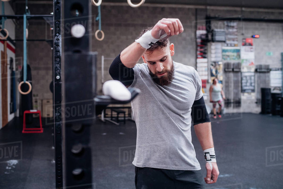 Exhausted young man taking break in gym - Royalty-free Stock Photo ...