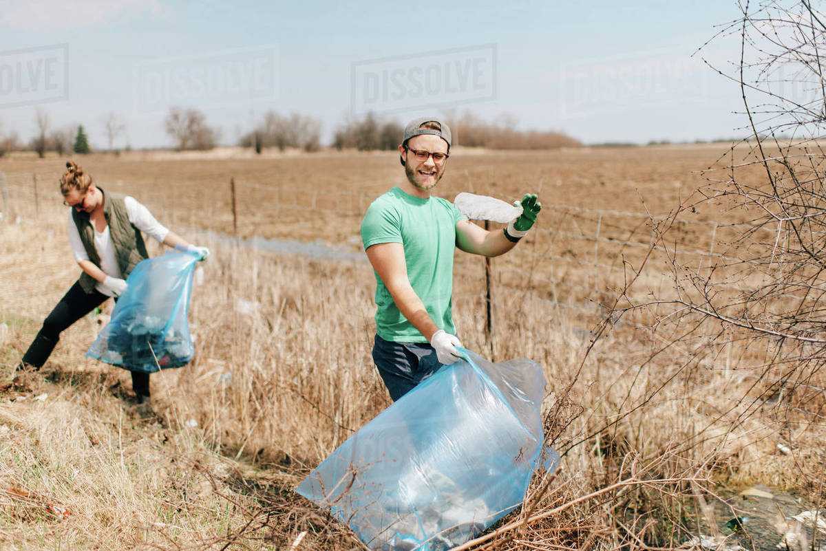 Couple picking up rubbish by field, Georgetown, Canada - Royalty-free ...