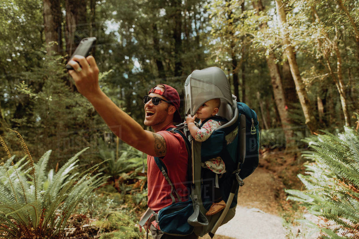 Father with baby taking selfie in forest, Queenstown, Canterbury, New ...