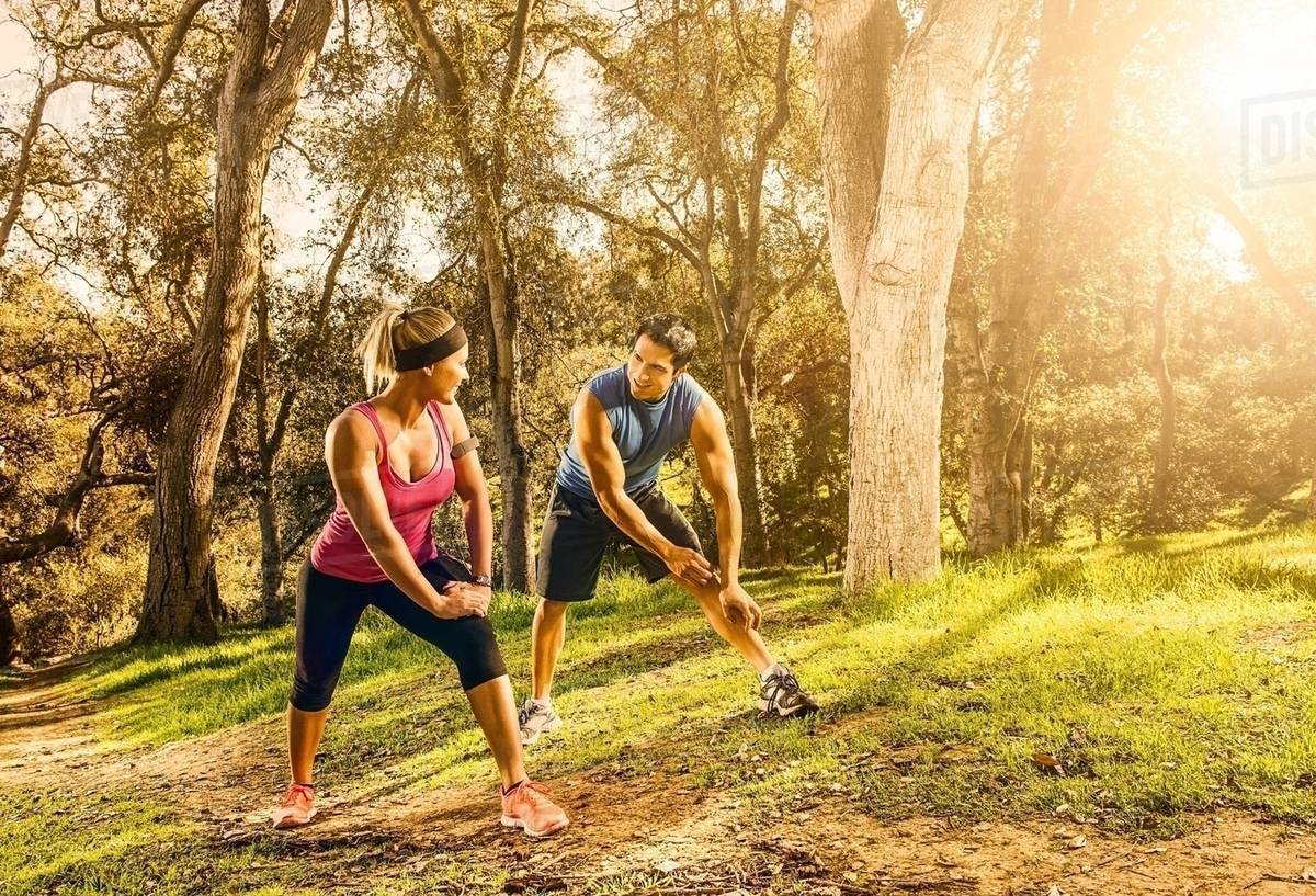 Two people exercising in forest doing warm up stretches - Stock Photo ...