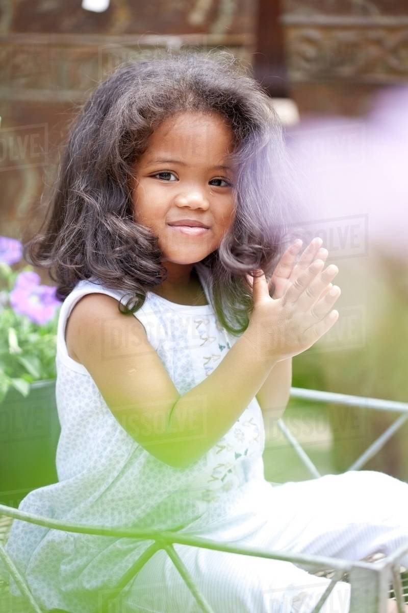 Smiling girl clapping outdoors - Royalty-free Stock Photo | Dissolve