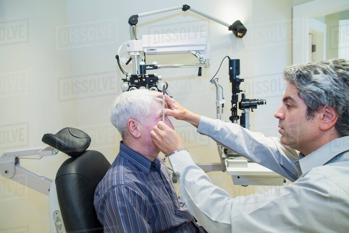 Doctor giving patient eye exam - Stock Photo - Dissolve