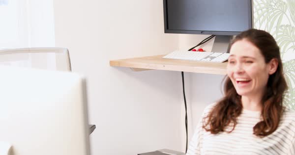 MS Woman laughing in front of computer monitor in office / London, UK ...