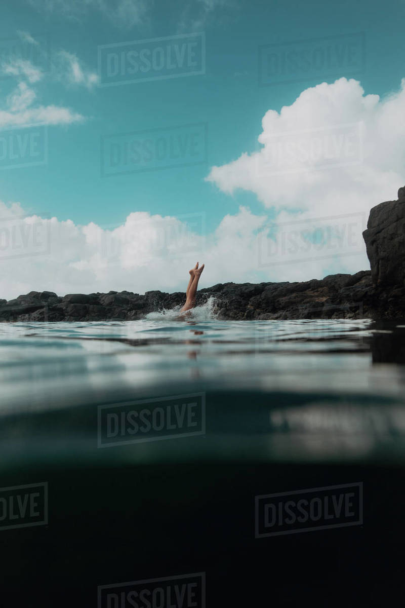 Swimmer diving off rocks into sea, Princeville, Hawaii, US - Royalty ...