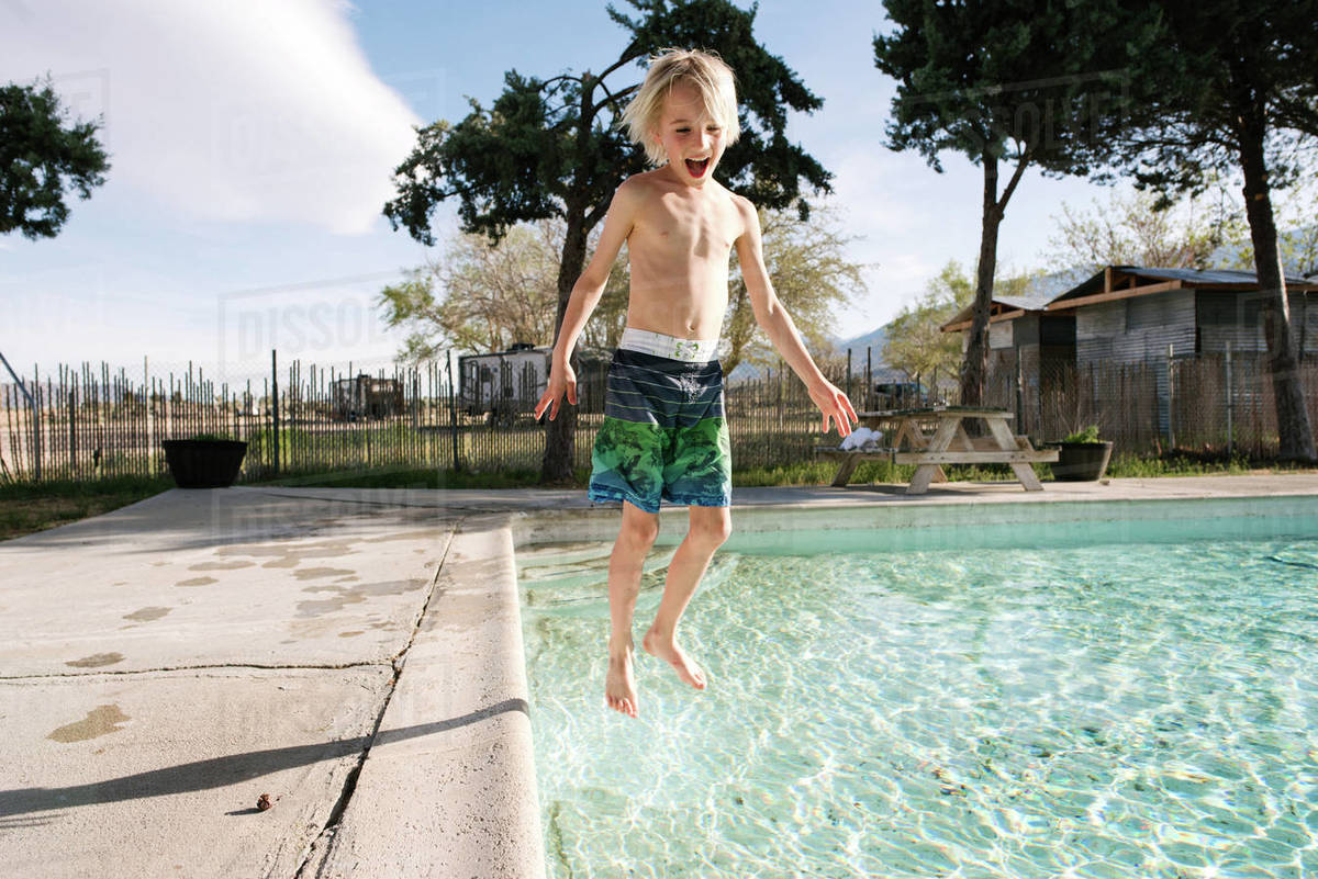 Boy jumping into swimming pool, Olancha, California, US - Royalty-free ...