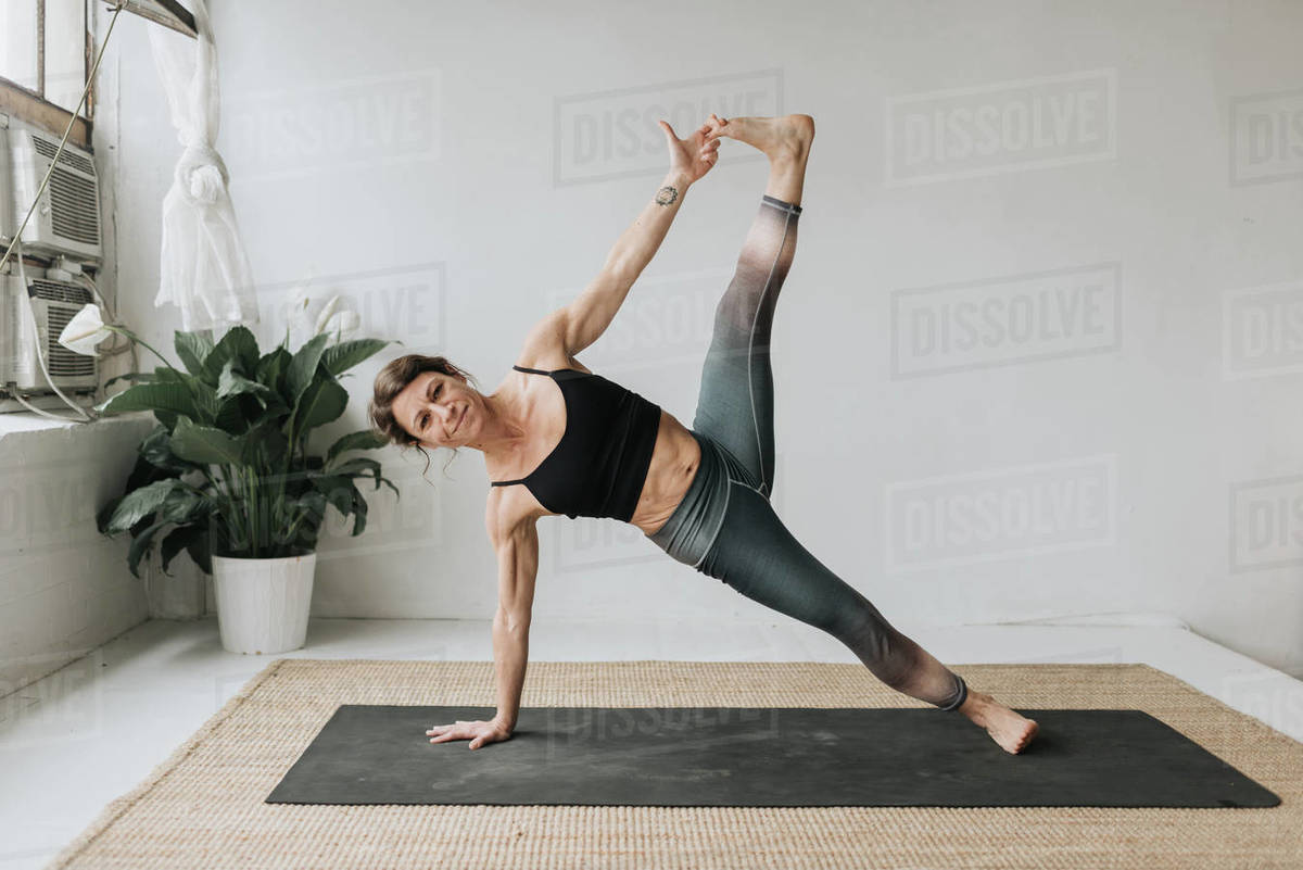 Woman practising yoga in studio - Royalty-free Stock Photo | Dissolve