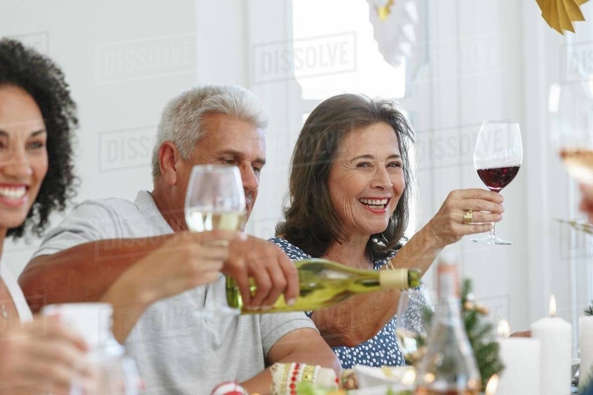 Family toasting wine at home party - Royalty-free Stock Photo | Dissolve