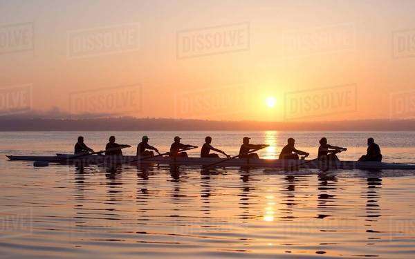 Nine people rowing at sunset - Royalty-free Stock Photo | Dissolve