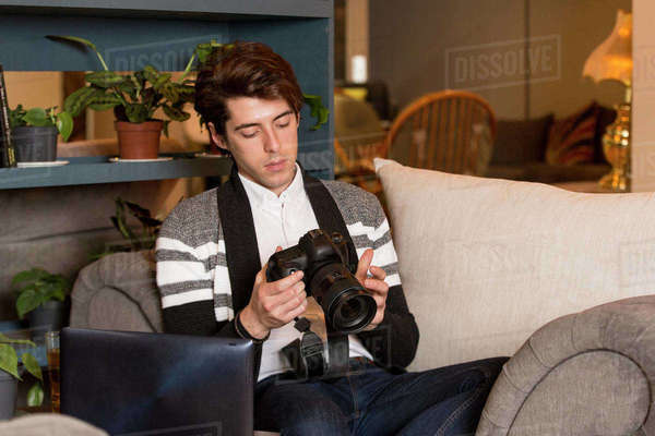 Man inspecting and learning to use camera in co-working space - Royalty ...