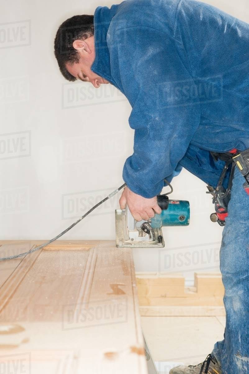A carpenter using a sander - Stock Photo - Dissolve