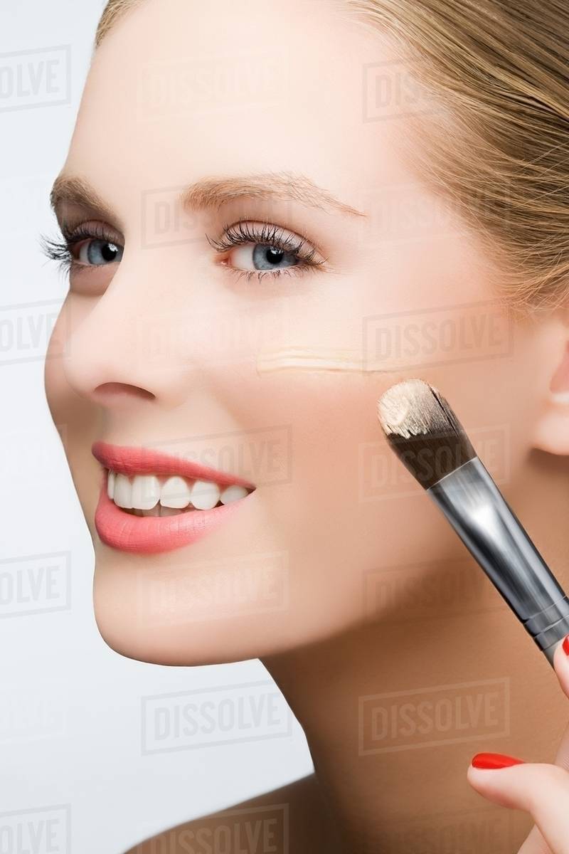 Woman applying foundation - Stock Photo - Dissolve