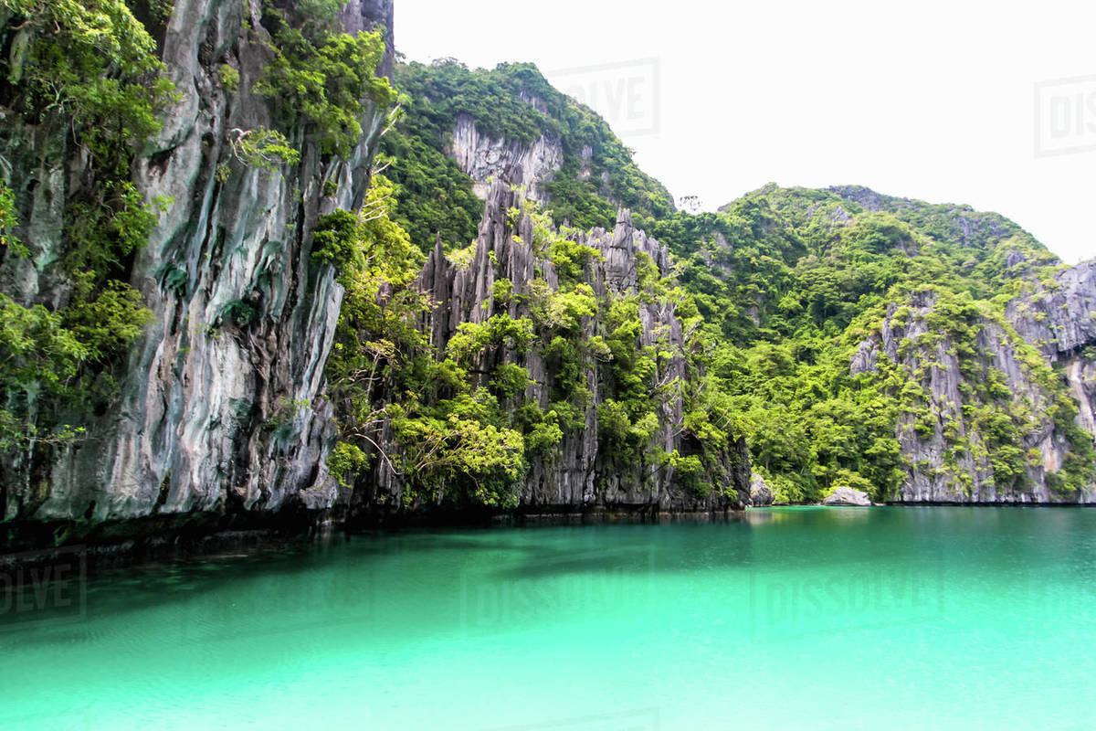 Secluded lagoon surrounded by beaches and high limestone cliffs near El ...