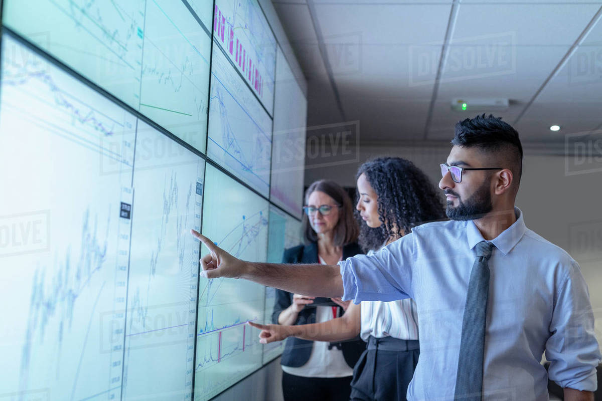 Business people discussing charts on interactive screens - Stock Photo ...