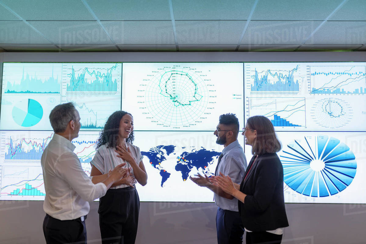 Business people discussing charts on interactive screens - Stock Photo ...
