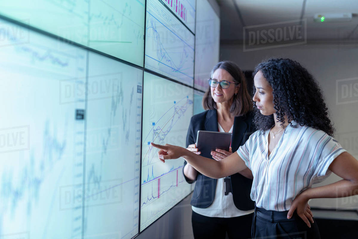 Businesswomen looking at charts on interactive screens - Stock Photo ...