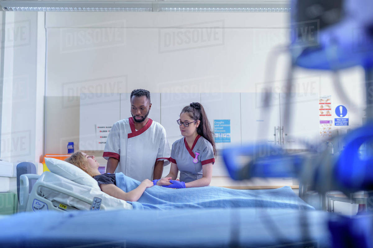 Nurses with patient in hospital ward - Royalty-free Stock Photo | Dissolve