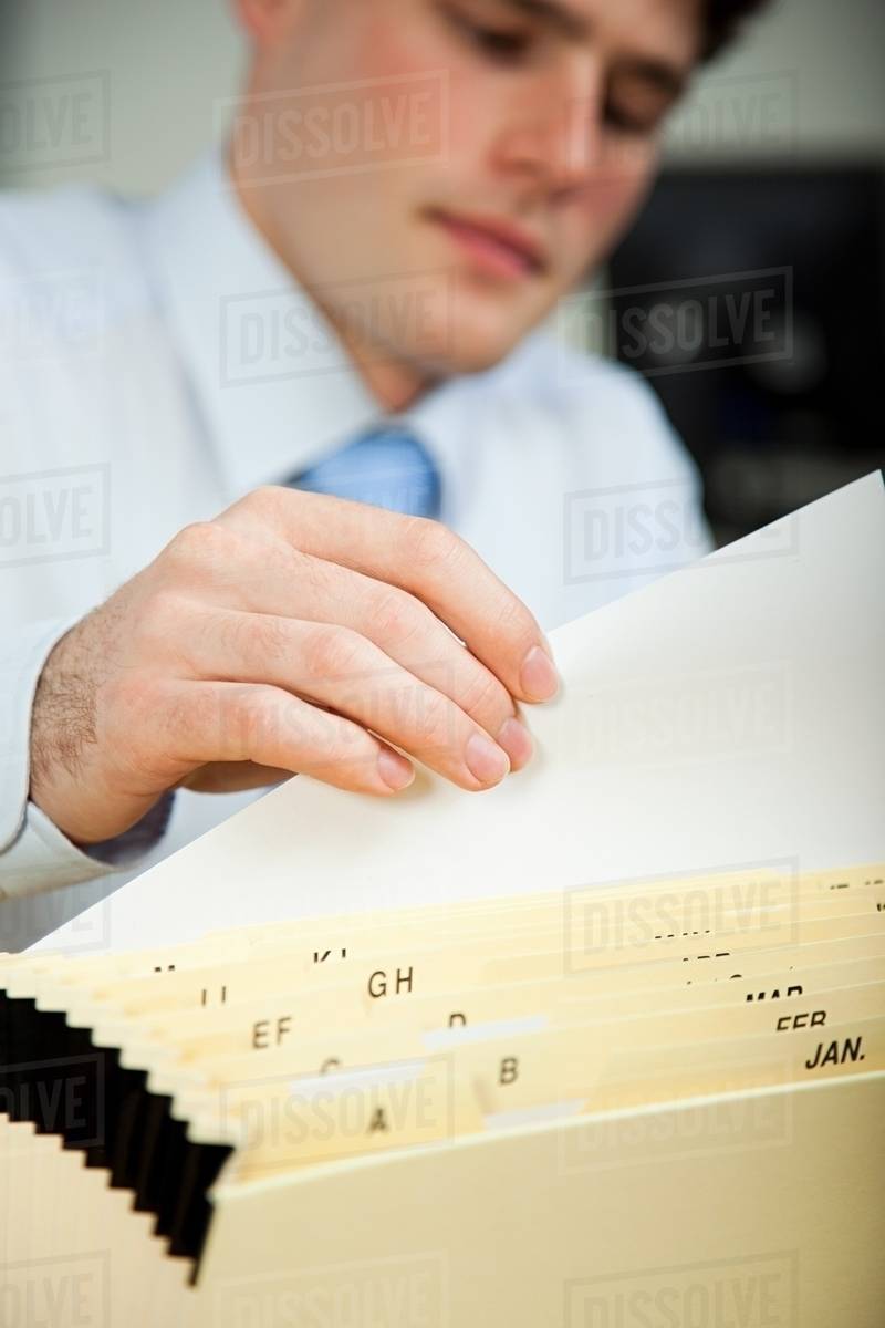 Office worker filing document - Stock Photo - Dissolve