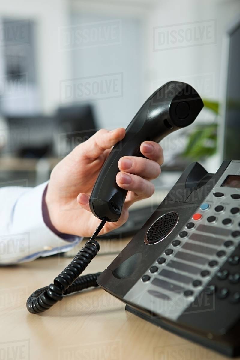 Office worker answering telephone - Stock Photo - Dissolve