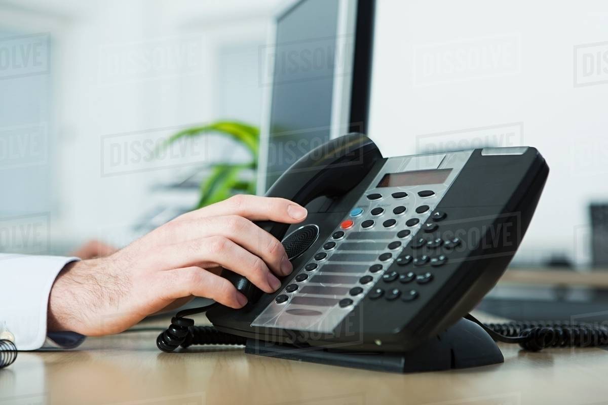 Office worker answering telephone - Royalty-free Stock Photo | Dissolve