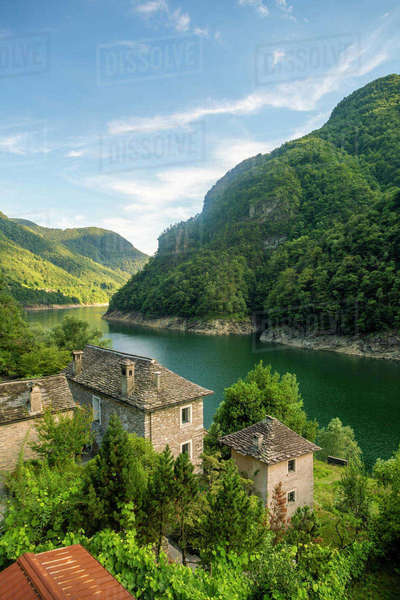 Switzerland, Ticino, Stone house and river in mountain landscape ...