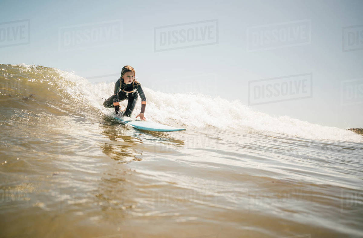 Girl surfing in the ocean - Royalty-free Stock Photo | Dissolve