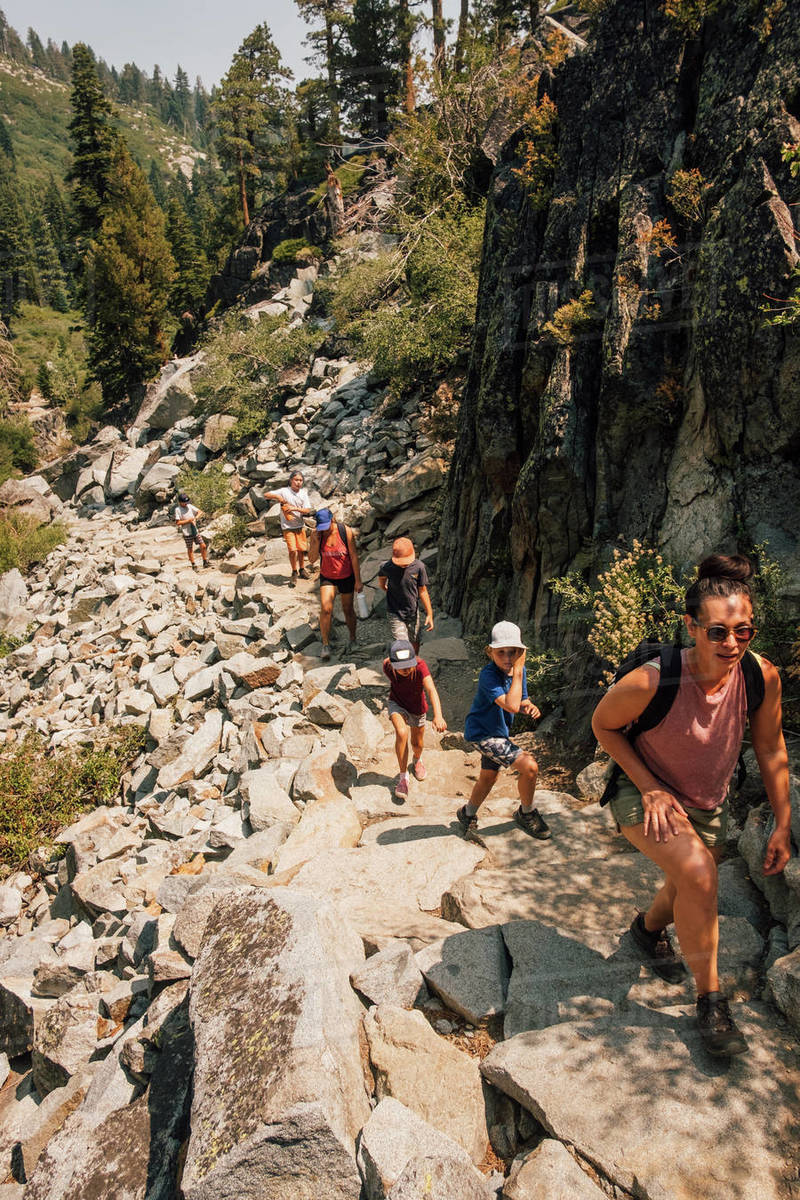 Family with children (6-7, 8-9, 12-13) hiking - Stock Photo - Dissolve