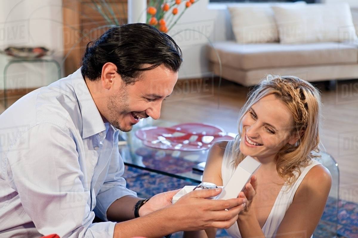 Woman giving gift of wrist watch to boyfriend - Stock Photo - Dissolve