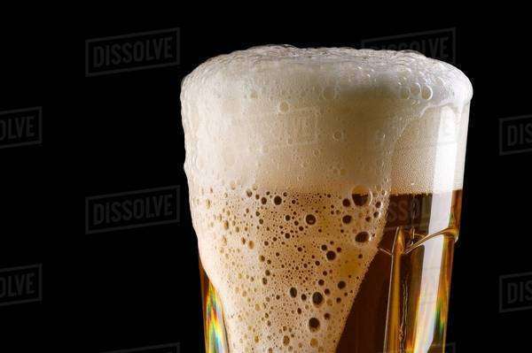 Overflowing glass of beer - Royalty-free Stock Photo | Dissolve