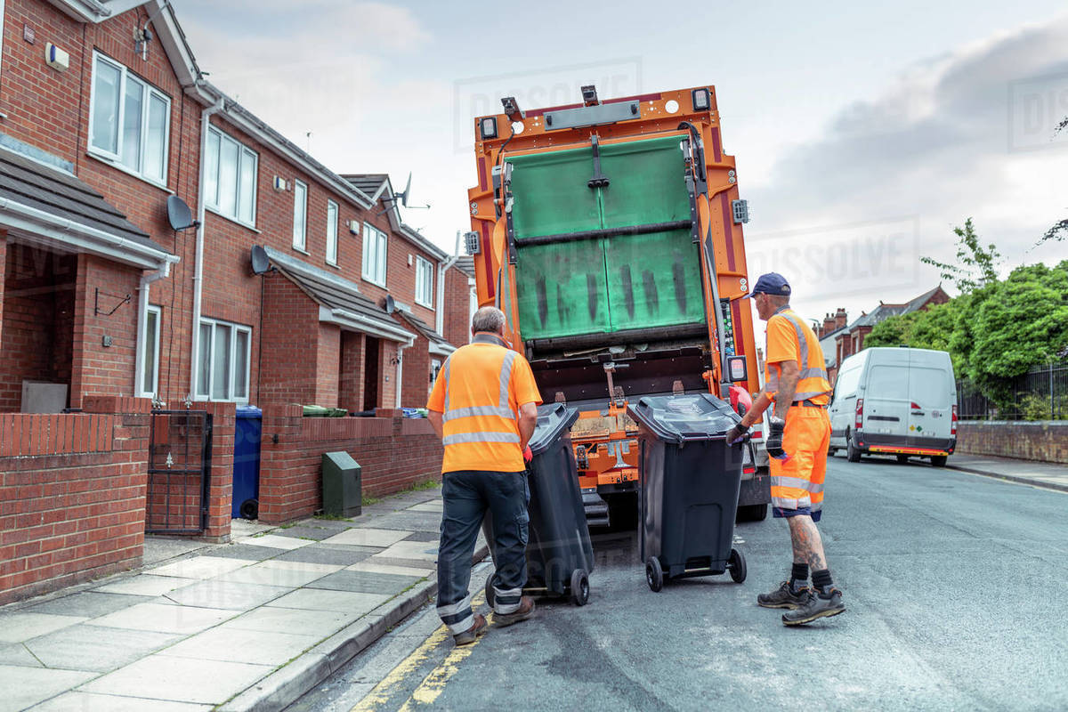 Refuse collectors with bins and refuse truck in street - Royalty-free ...