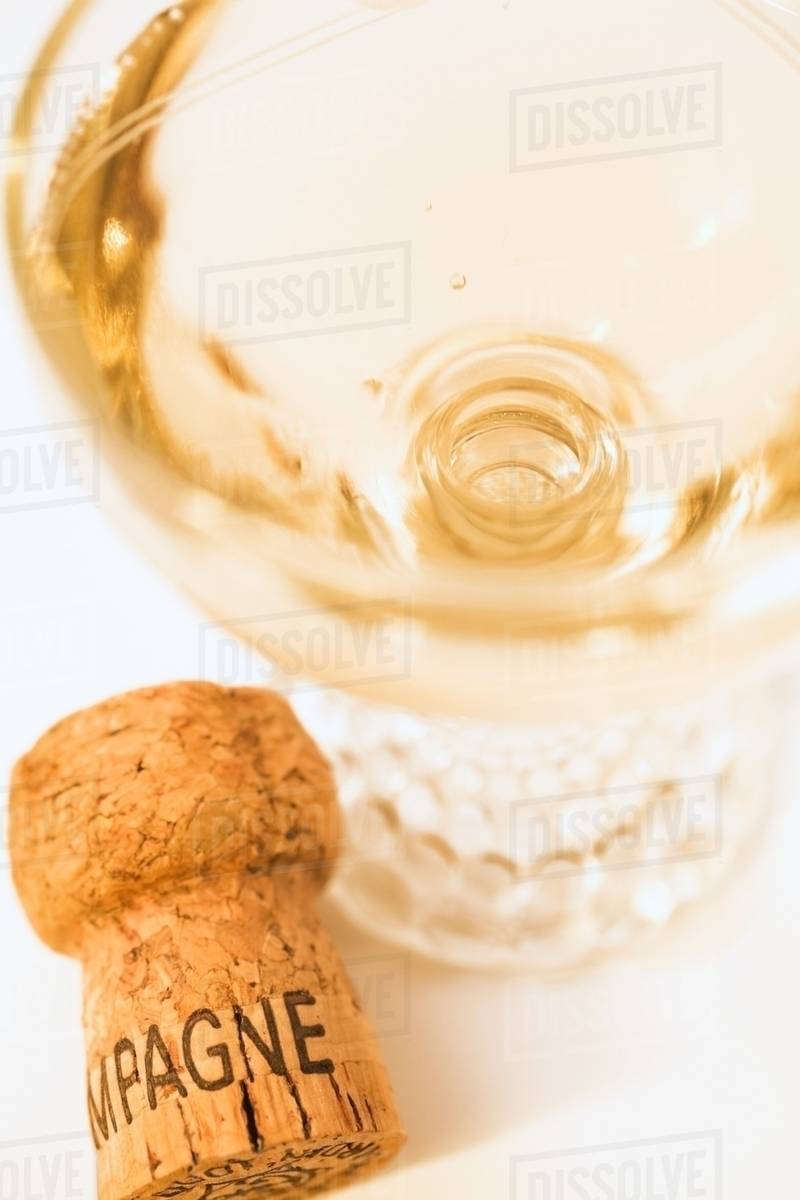 Glass of champagne and cork, close up - Stock Photo - Dissolve
