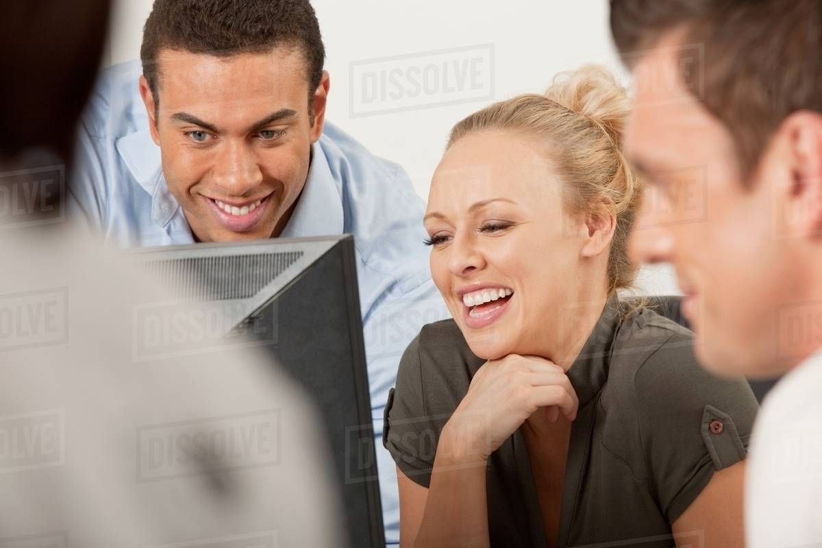 Colleagues looking at a computer screen together - Stock Photo - Dissolve