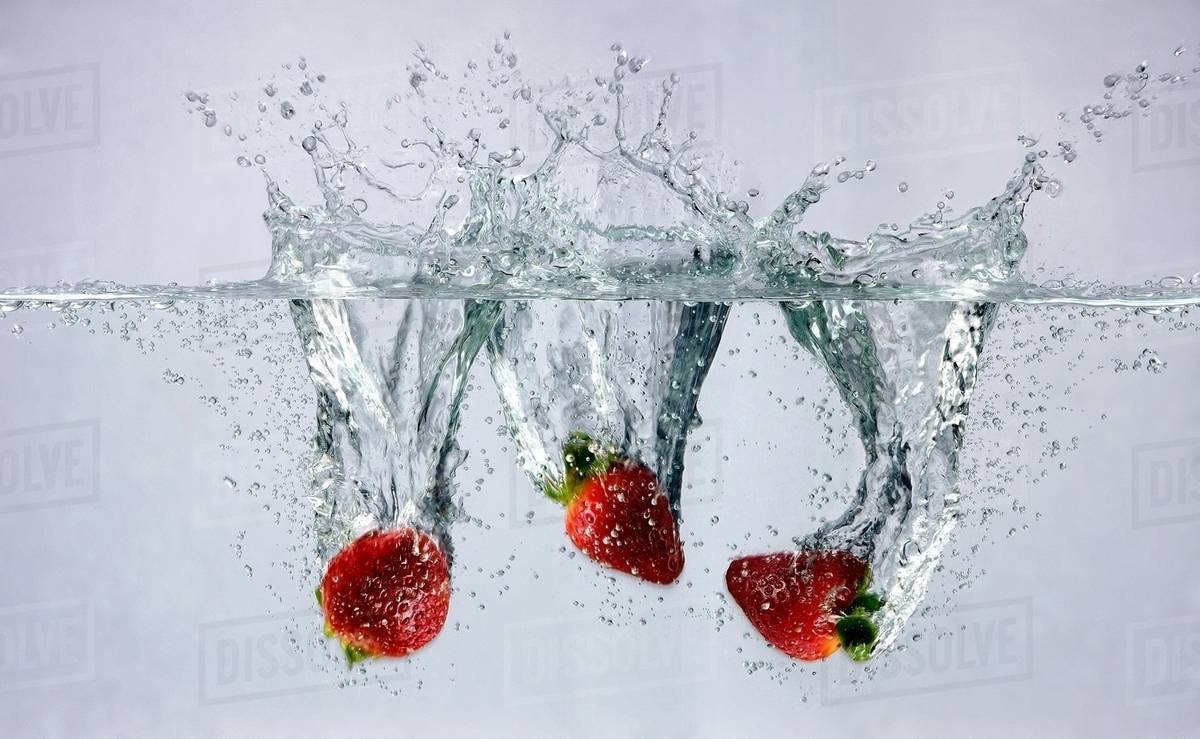 Strawberries falling into water - Stock Photo - Dissolve