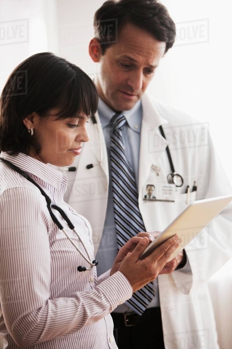 Doctors in discussion over patients records in hospital - Stock Photo ...