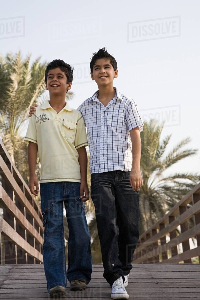 Two boys walking along a bridge - Stock Photo - Dissolve
