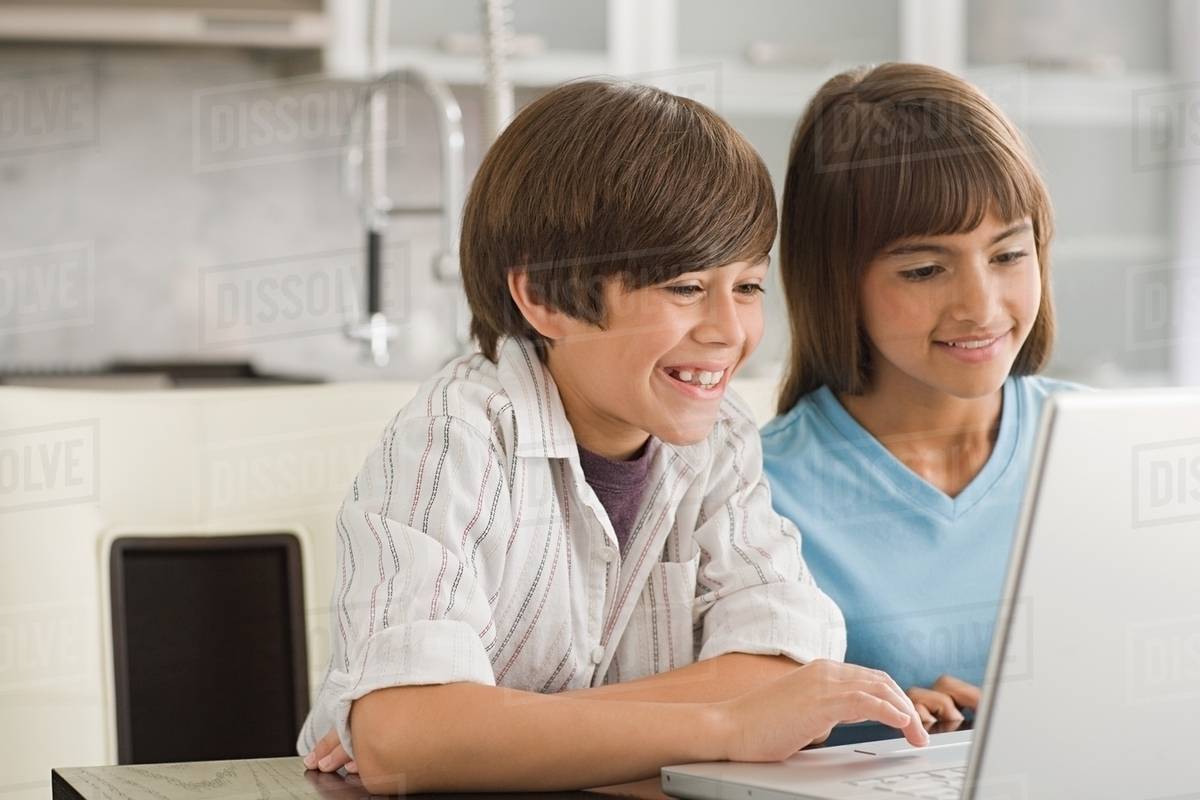 Brother and sister using a laptop computer - Royalty-free Stock Photo ...