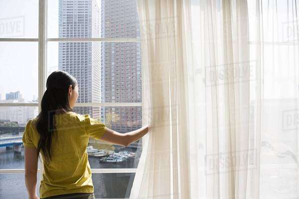 Woman lookinng through a window - Royalty-free Stock Photo | Dissolve