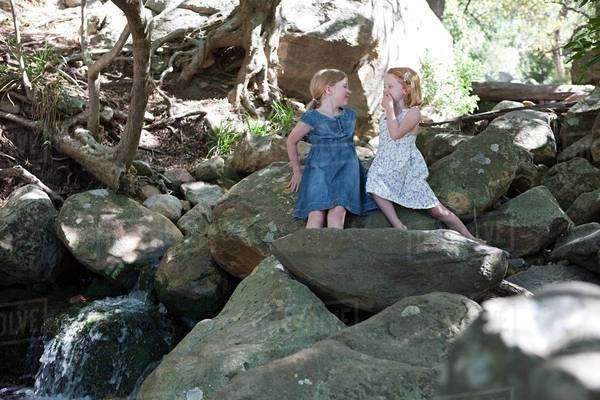 Two girls on rocks by river - Royalty-free Stock Photo | Dissolve