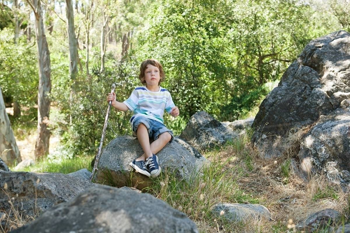 Boy sitting on rock - Royalty-free Stock Photo | Dissolve